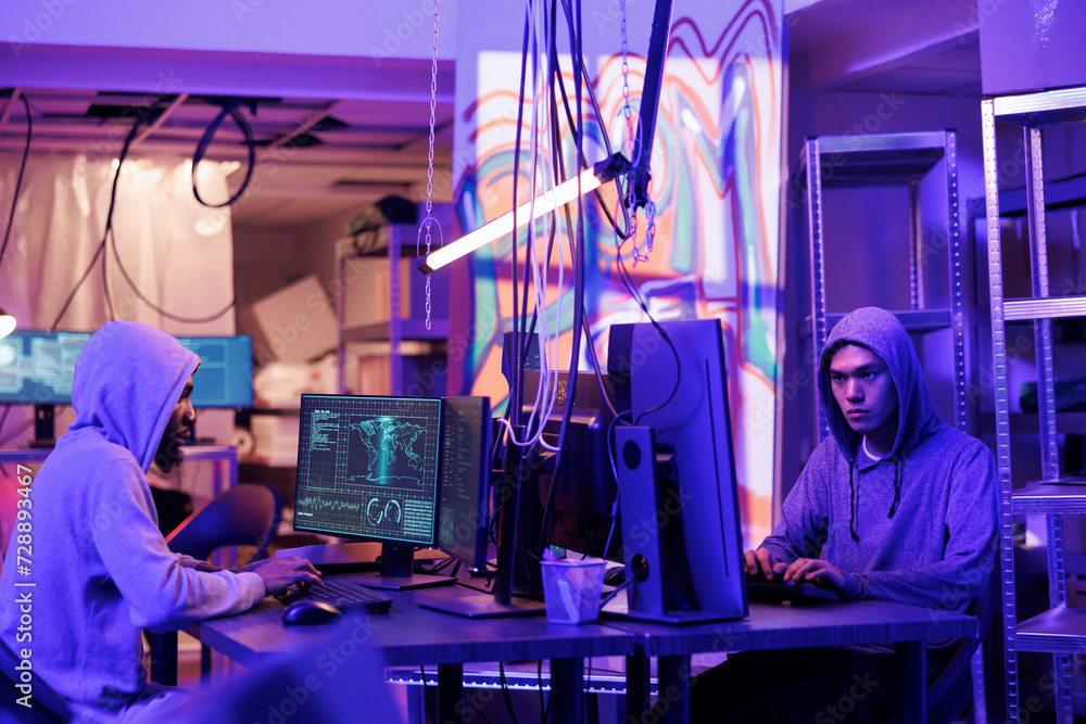 Foto Stock Hackers collaborating while coding virus software, doing illegal activities and ...