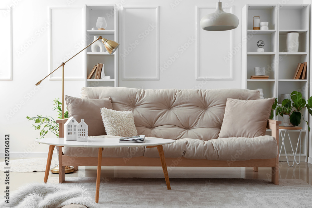 Interior of light living room with cozy white sofa and coffee table ...