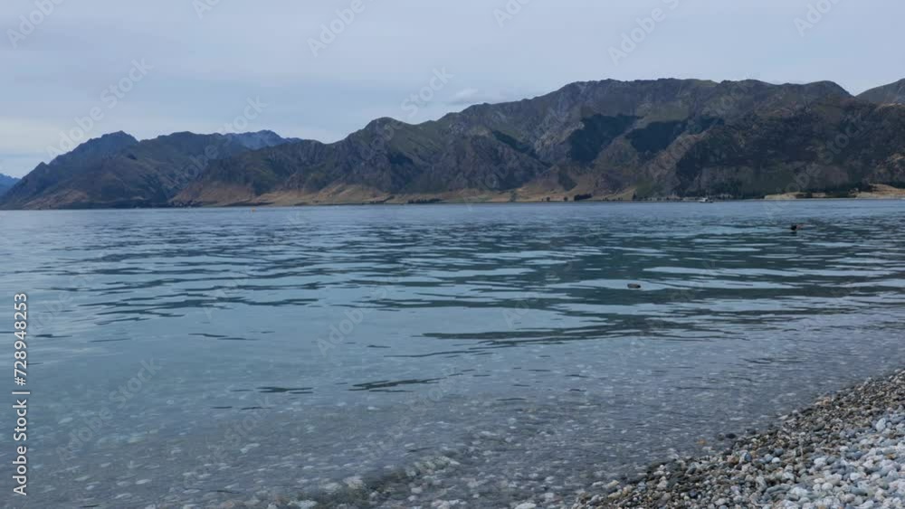 Vidéo Stock Waves arriving to the shore at lake Hawea, blue and clear ...