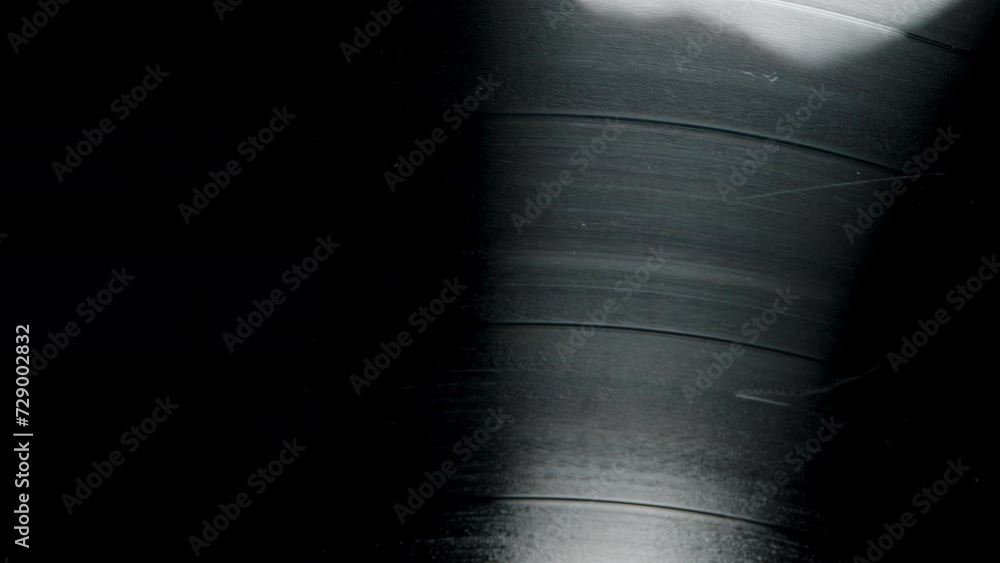 Vidéo Stock Macro zoom of a rotating vinyl record on a black background ...