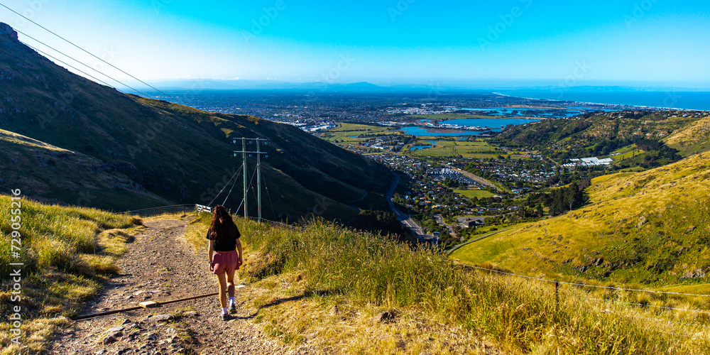 pretty girl standing at the top of hill and watching the panorama of ...