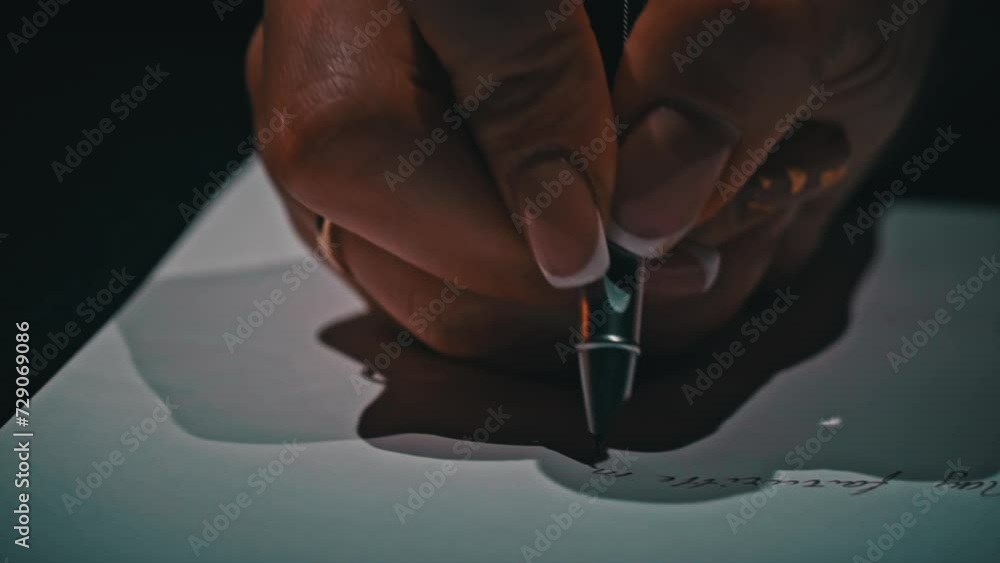 Man's hand writes with an antique pen on white paper close-up. Writes a ...