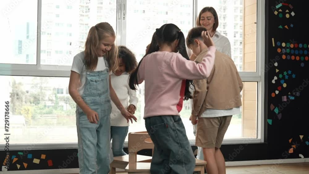 Diverse children playing musical chairs games while young smart ...