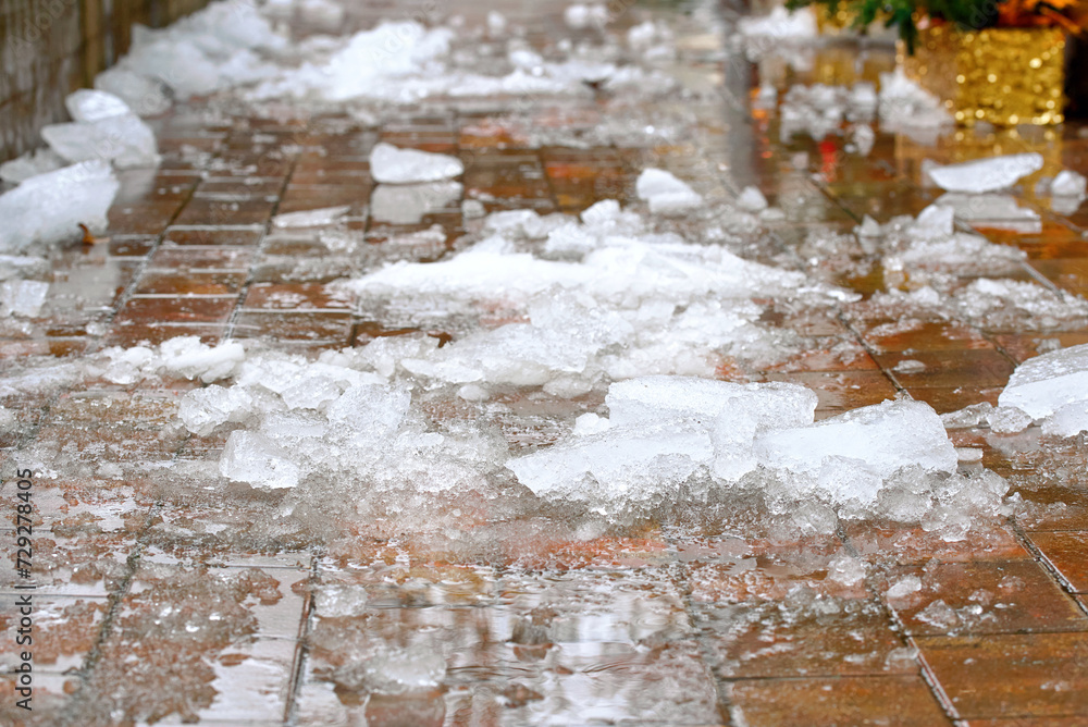 Ice and snow melting on paving slabs, ice thaw on sidewalk. Wet and ...