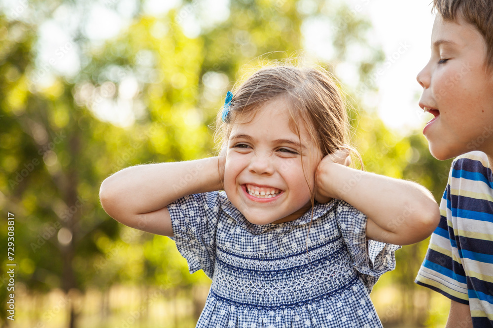 Kids being silly together - boy shouting and roaring at little girl ...