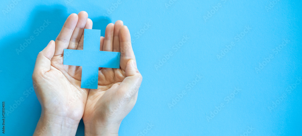 Human hand holding blue virtual hospital plus sign, healthcare ...