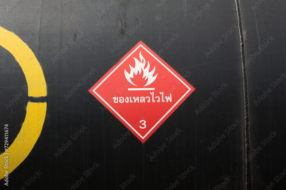 Caution sign of the Flammable liquid (in Thai langauge) on red placard ...