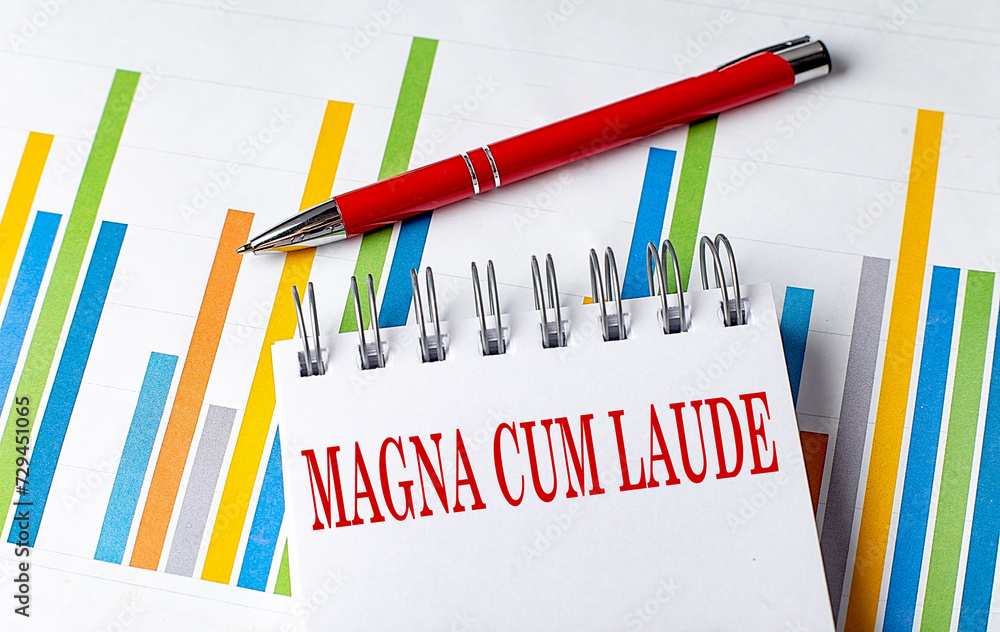 MAGNA CUM LAUDE text on a notebook with chart and pen business concept ...