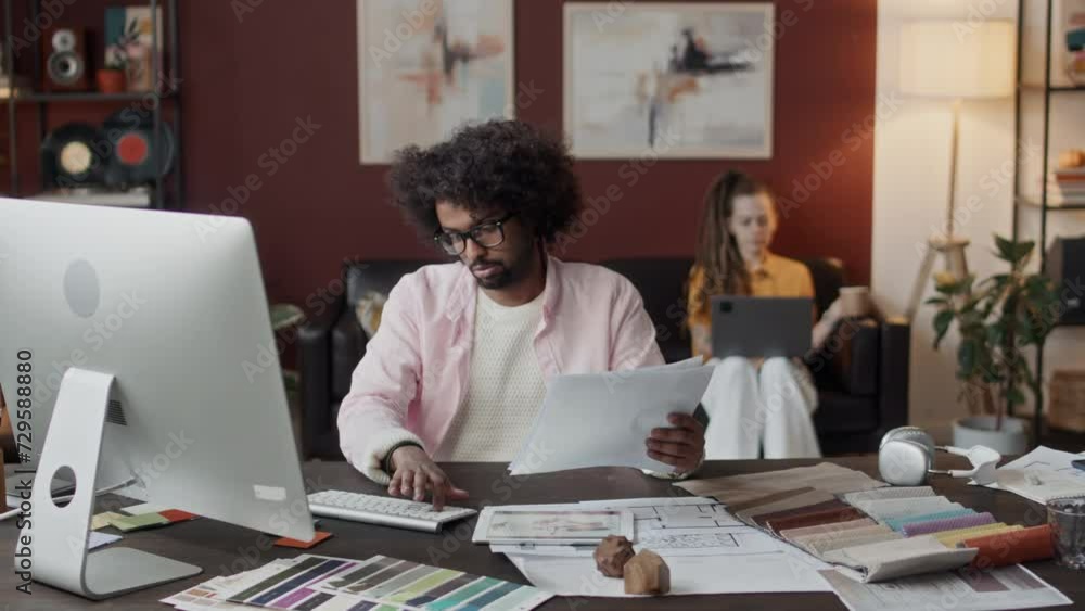 Waist up of young Biracial male interior designer looking at drawing ...