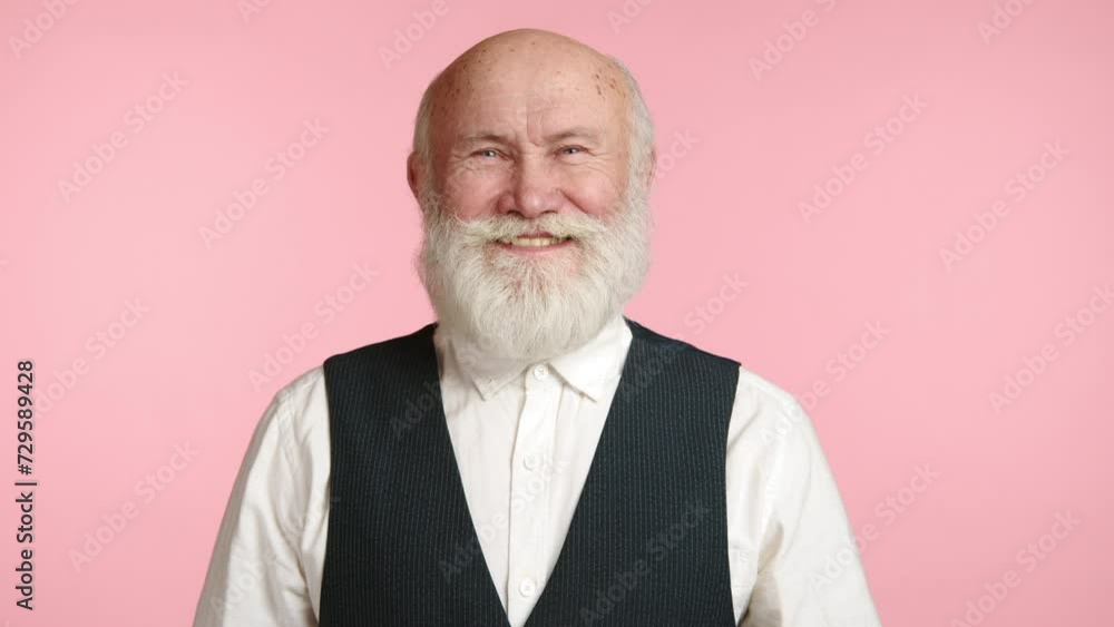 An affable elderly man beams with a soft smile, his white beard ...