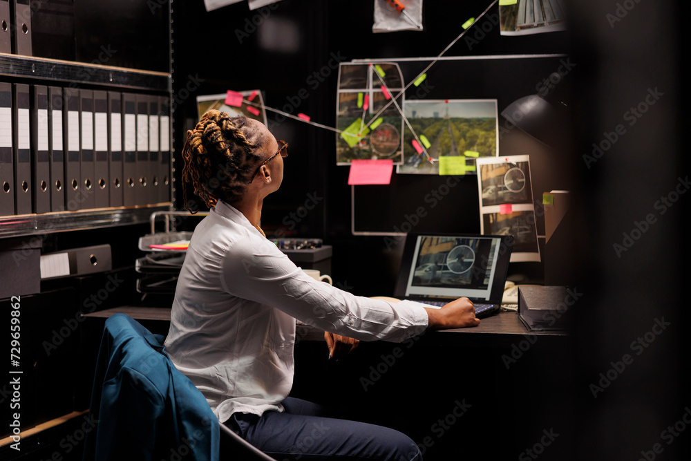 African american policewoman analyzing evidence board while solving ...