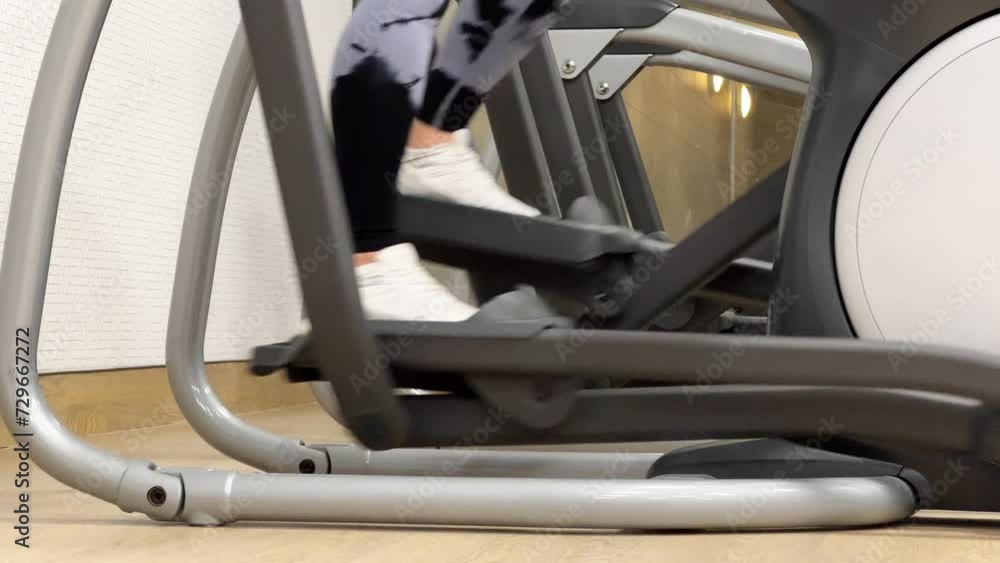 Cardio workout on an elliptical trainer. Horizontal video of walking ...