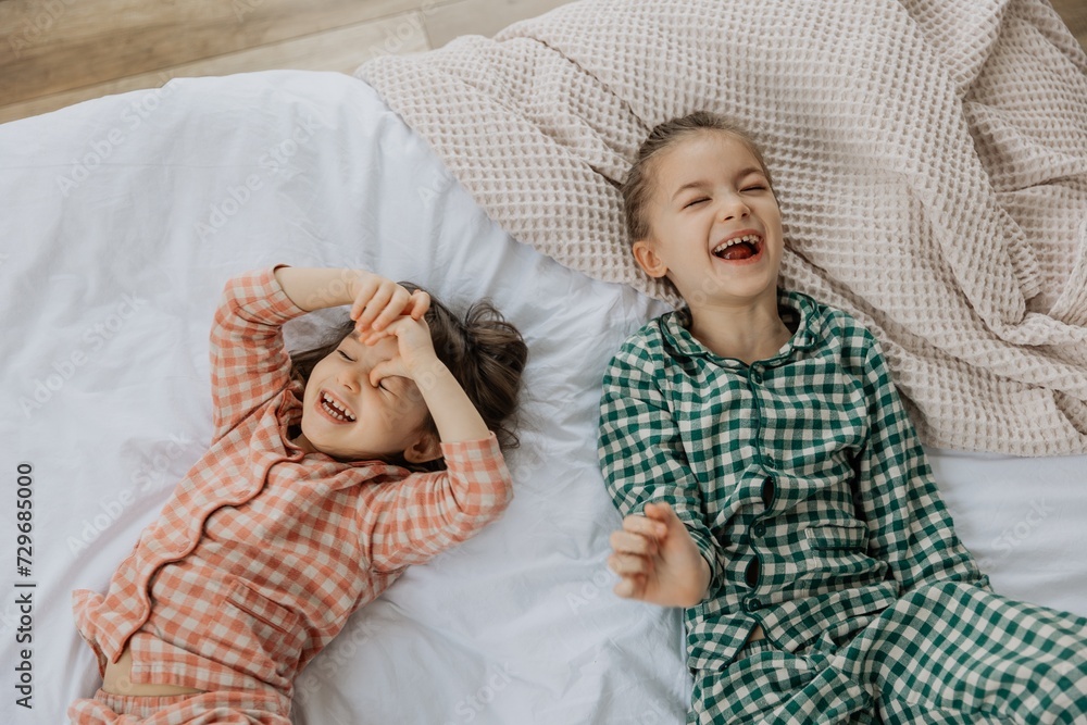 Morning awakening little girls in a bed. Kids wakes up in the bedroom ...