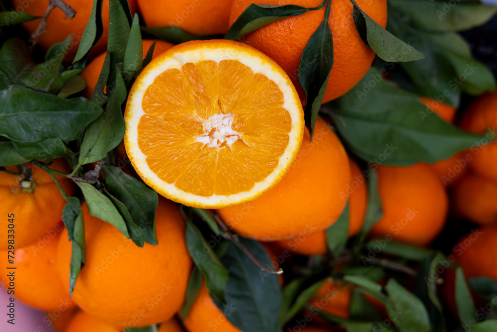 orange mandarin cut in half without stones resting on other mandarins ...
