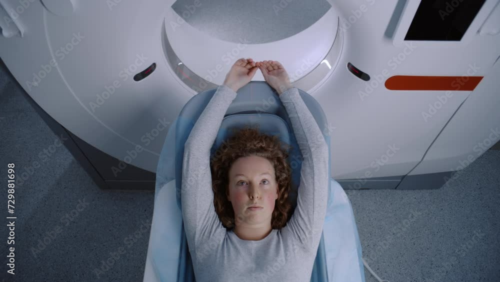 Close up shot of female patient on CT, PET, or MRI bed moving inside ...