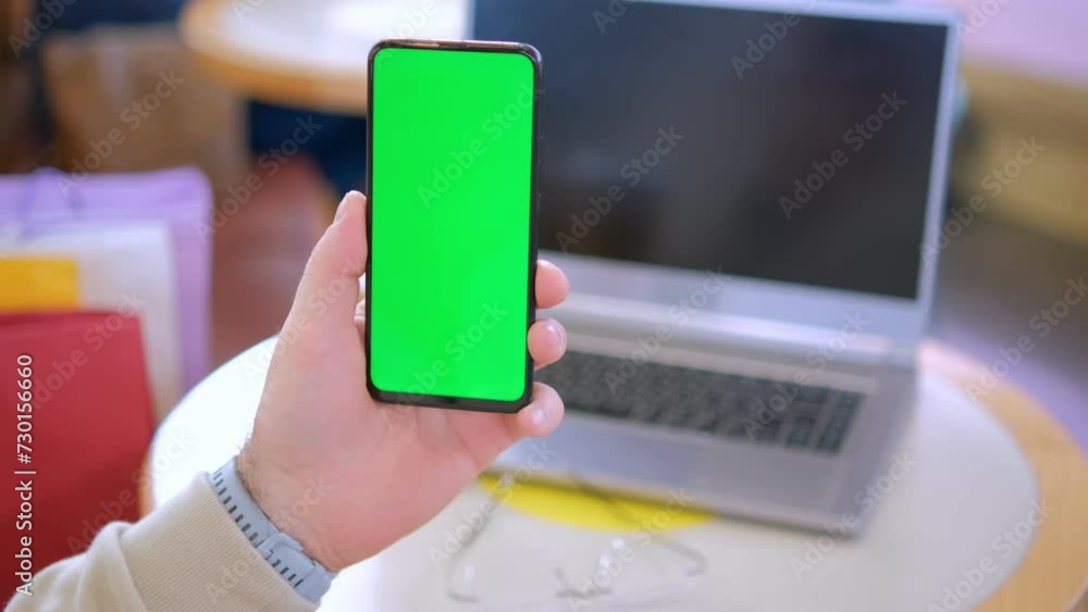 Male hands using smartphone mobile with empty green screen top view ...