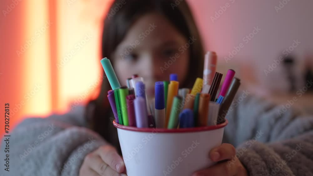 One little girl grabbing bucket filled with coloring pen trying to ...