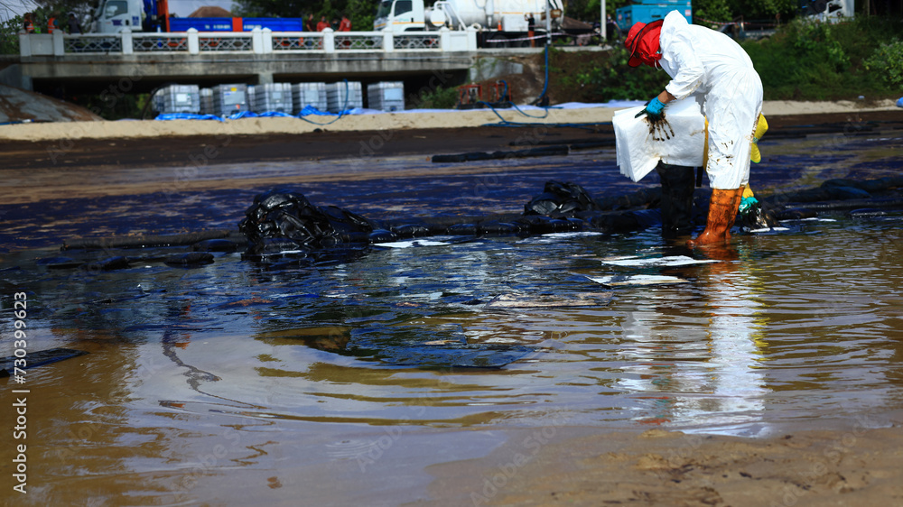 Professional team and volunteer wearing PPE clean up dirty of oil spill ...