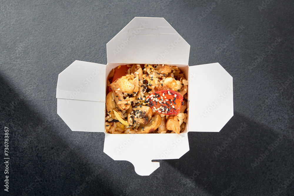 Stir-fried rice with chicken and vegetables in a wok, served in a ...