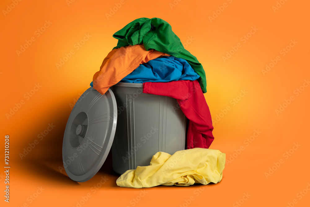 Trashcans, rags, clothes waste sorting, sustainability. Fast fashion is ...