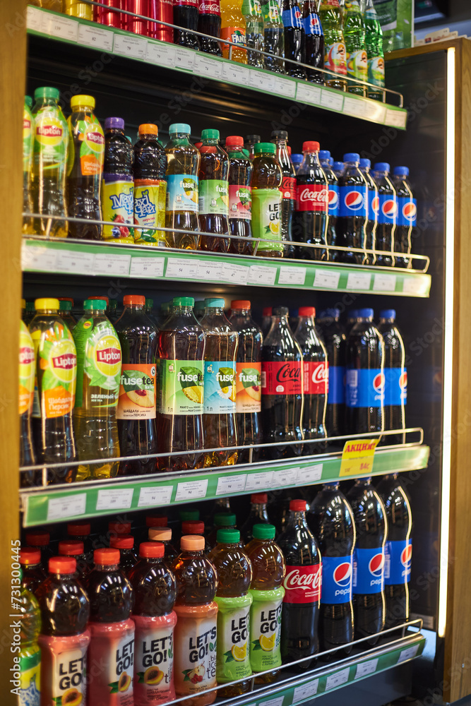 Plastic bottles of soda and cold tea different brands. Coca Cola, Pepsi ...