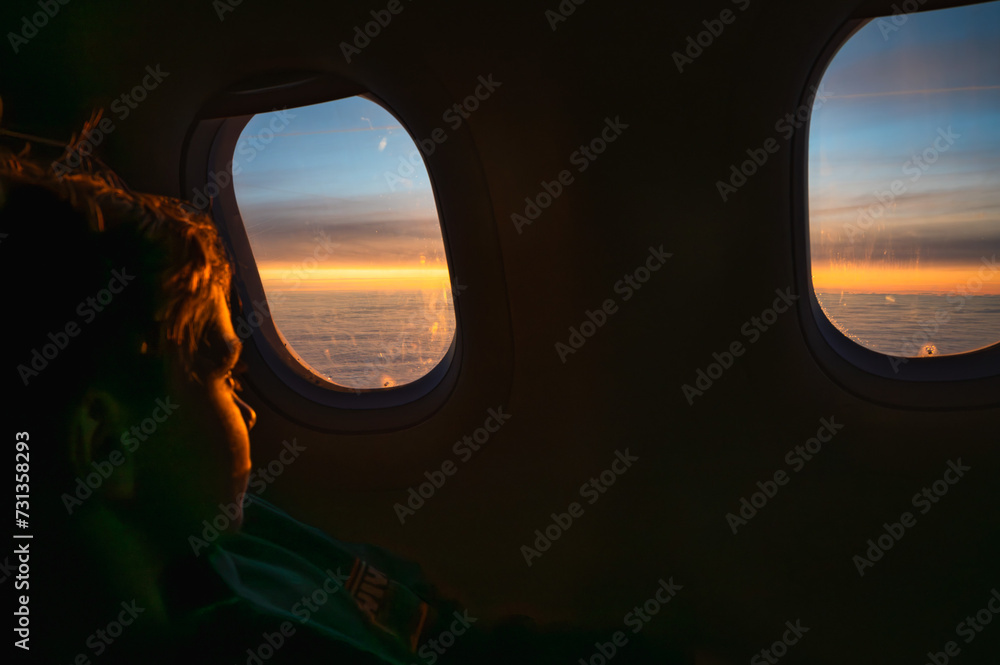 Boy looking throw the window in the flying airplane. Stock Photo ...