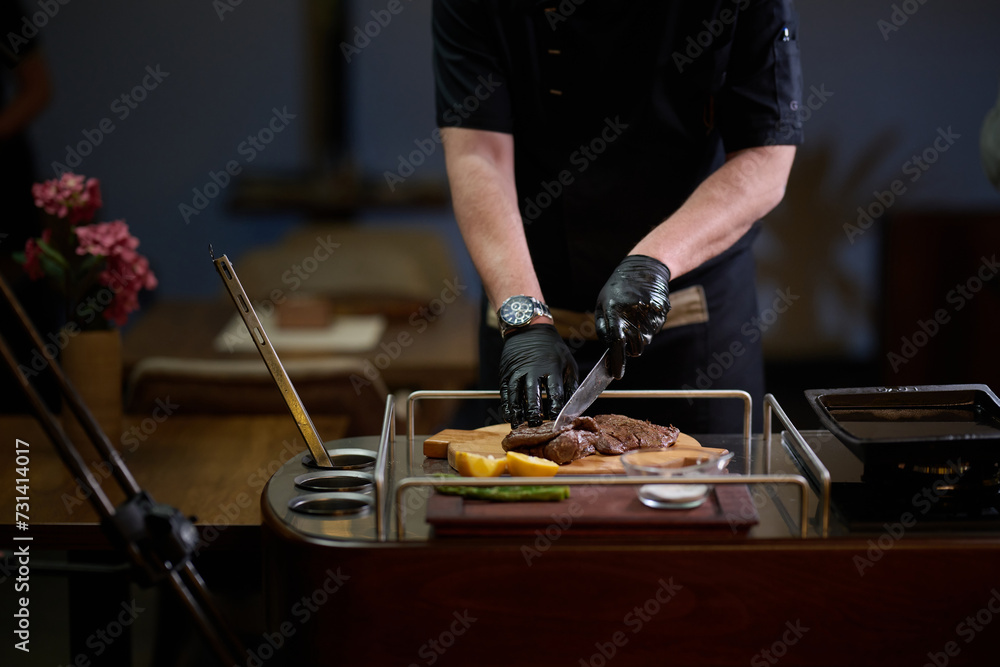 Close-up shot, a professional chef expertly prepares a delicious steak ...