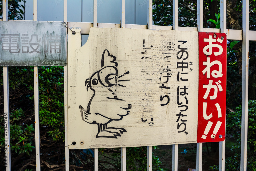 Tokyo, Japan, 2 November 2023: A worn and faded warning sign with a ...
