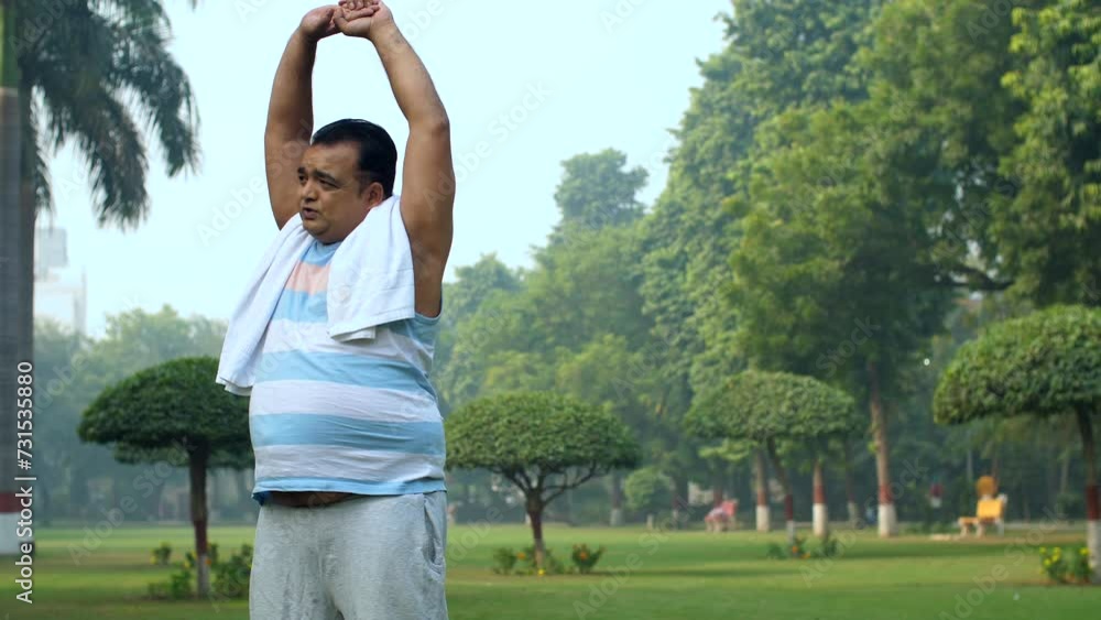 Fat Indian man stretching his body in a public park - fitness morning ...