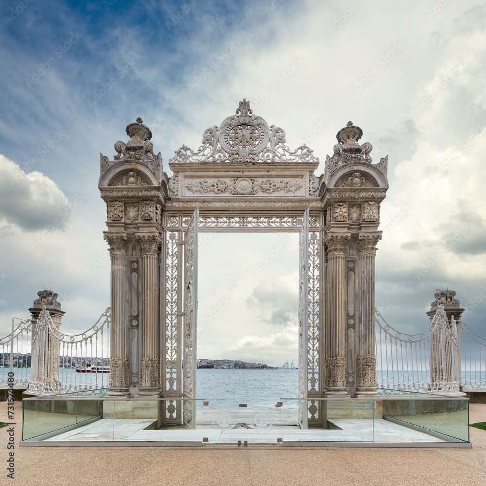 Pair of elaborately decorated white painted metal gates leading to the ...