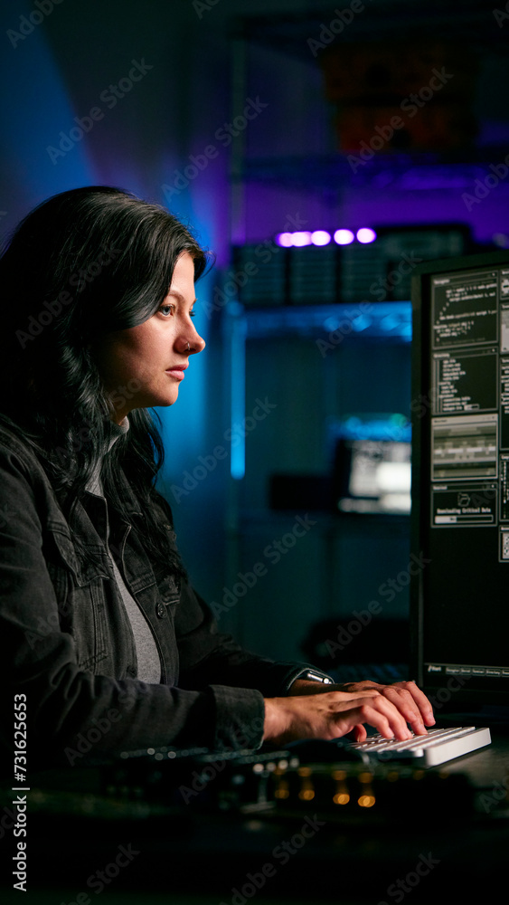 Low Key Lighting Shot Of Female Computer Hacker Sitting In Front Of Screens Breaching Cyber ...