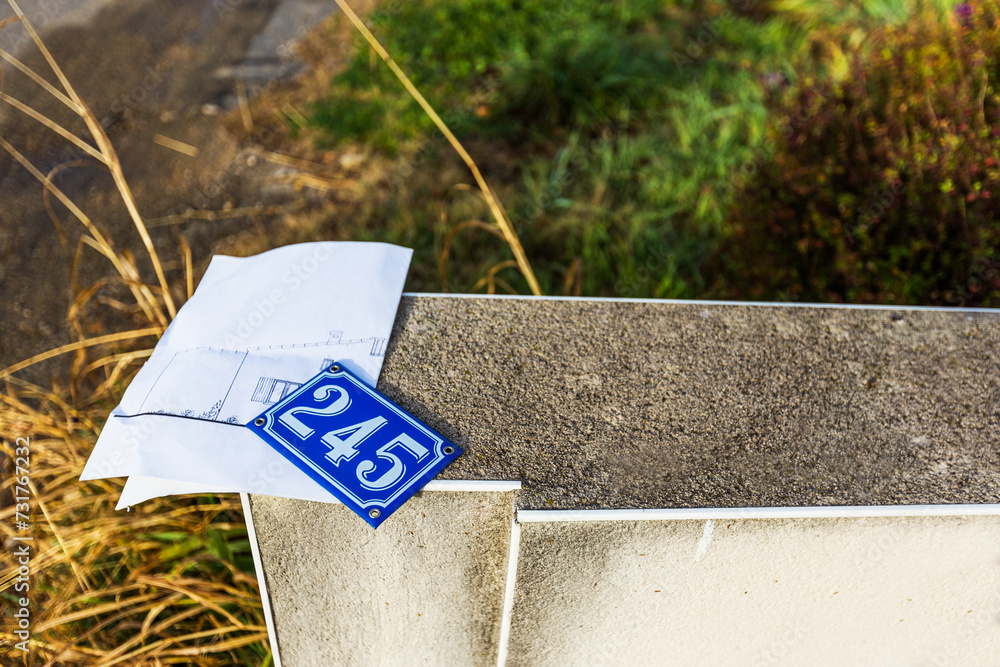 Plaque de rue et plan de future construction posés sur un mur Stock ...