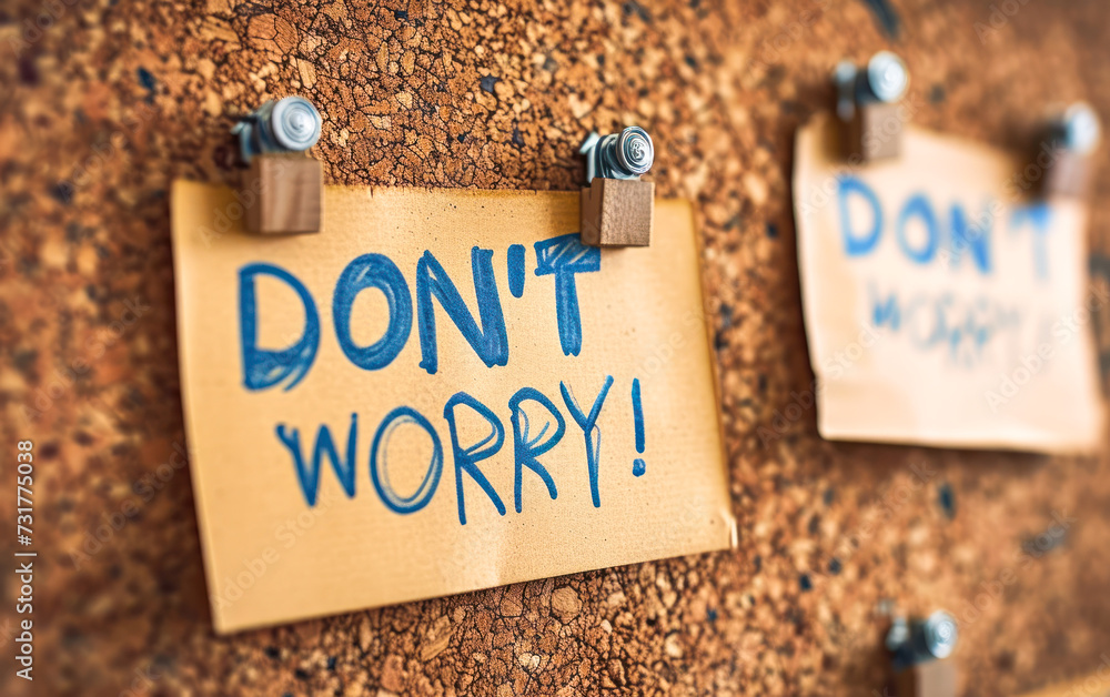 Reassuring note with 'DON'T WORRY!' message pinned on a cork bulletin ...