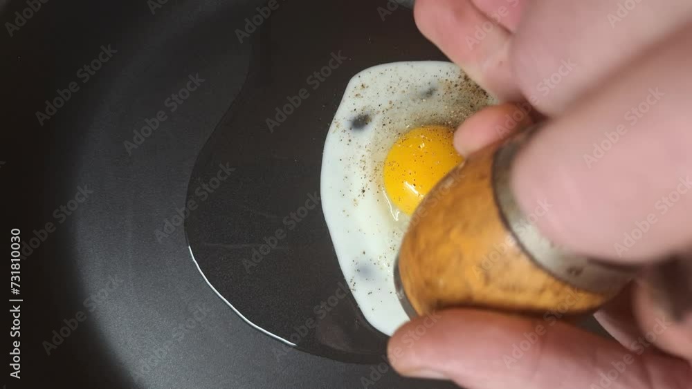 Crack the egg into the pan. Smashed egg on the pan. Spicing up a ...