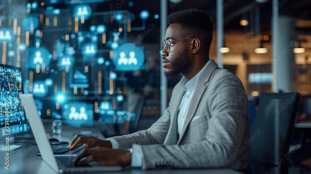 A handsome short black american project manager working on a computer ...
