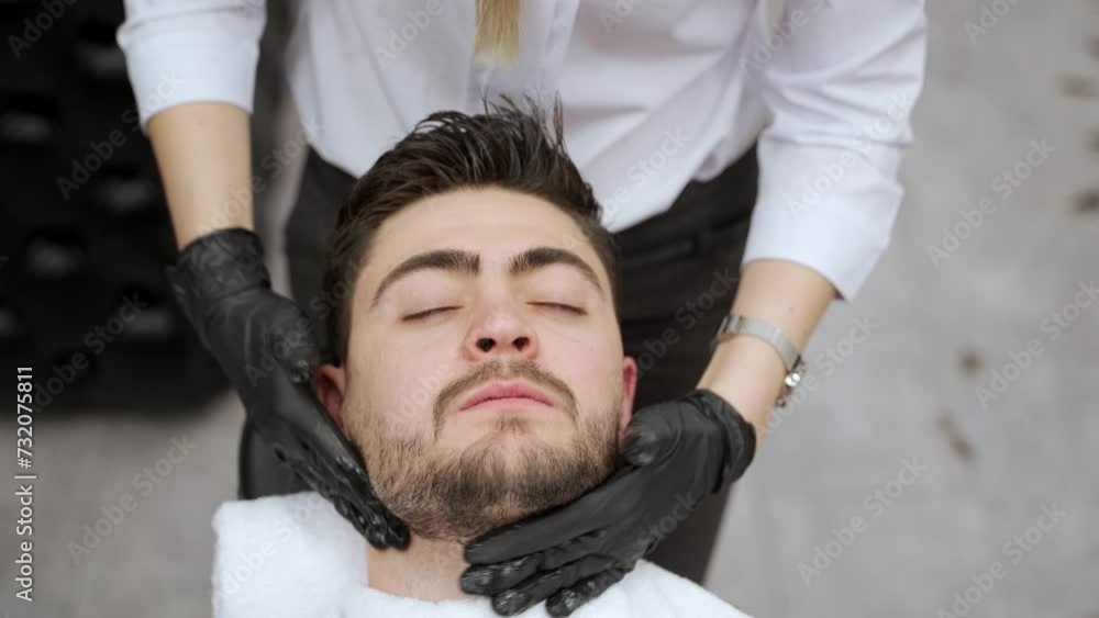 Male client enjoys relaxing neck and facial massage at barbershop ...