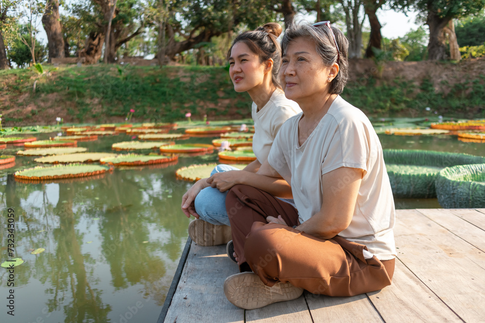 Side view of asian Thai Chinese elder mother and daughter sitting on ...