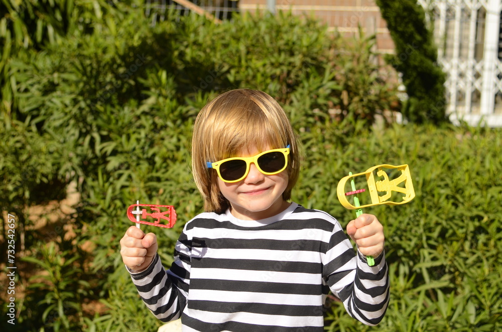 Purim. A child with a grager and ratchet celebrates the Jewish joyful ...