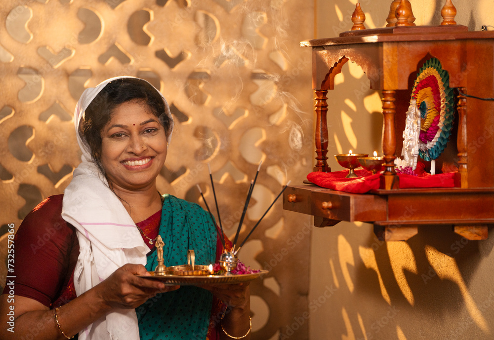 Devotional Indian woman with Pooja thali plate offering aarthi to god ...