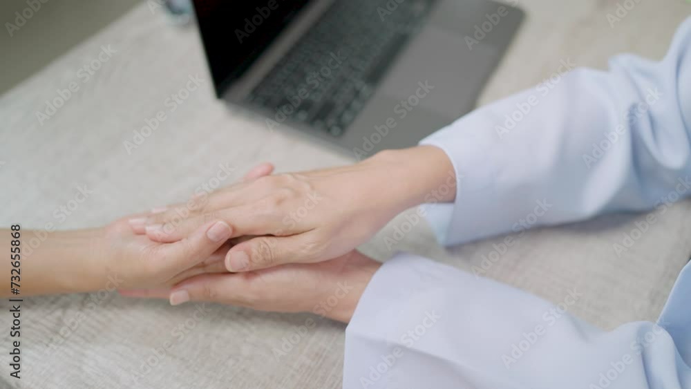Female nurse doctor wearing a white uniform holds a patient's hand ...