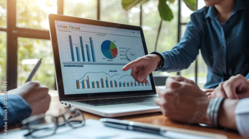 person working on a laptop which displays various colorful charts and ...