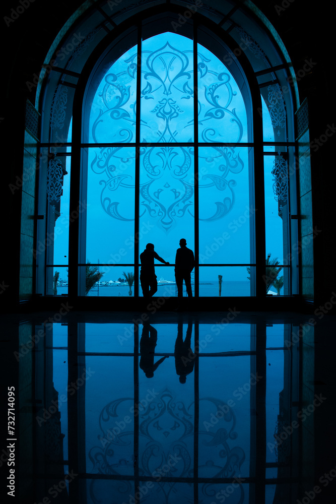 Silhouette of two men standing in front of a window in Emirates Palace ...