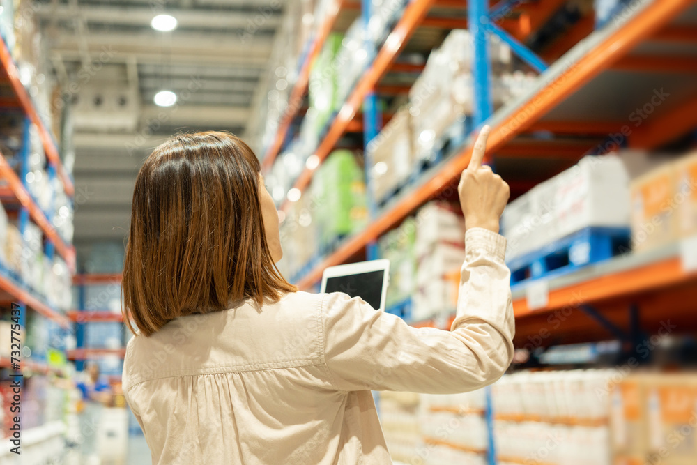 Warehouse worker hands holding tablet check stock on tall shelves in ...