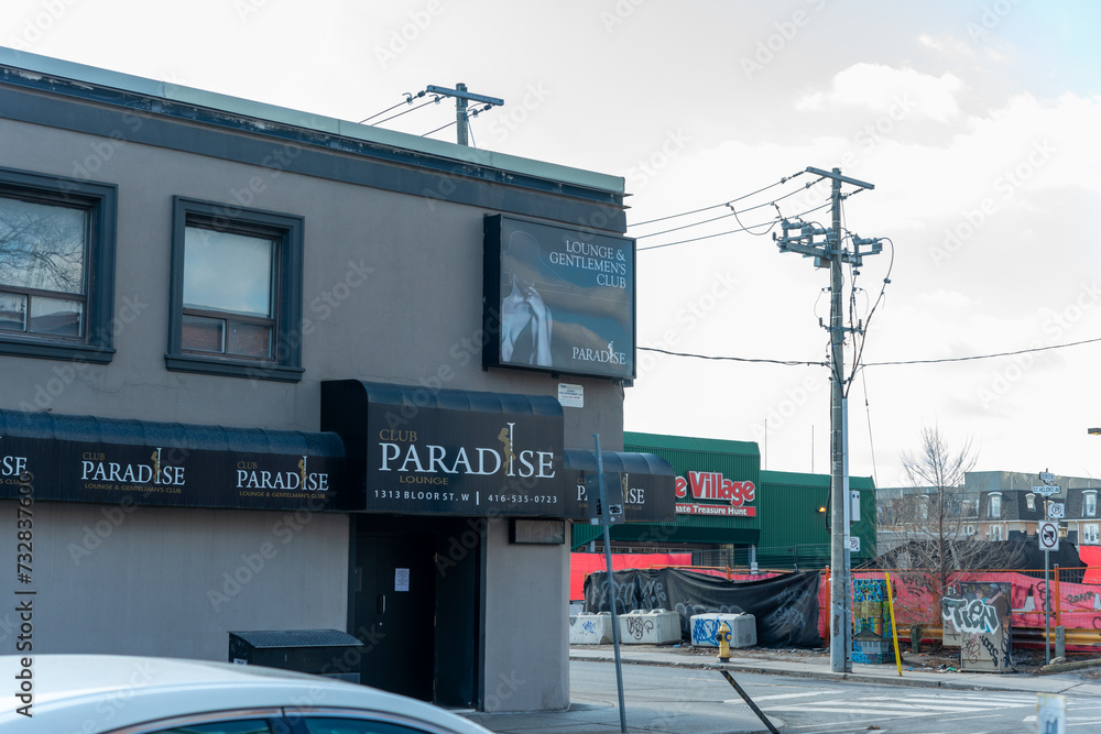 exterior building facade entrance and sign of Club Paradise, a night ...