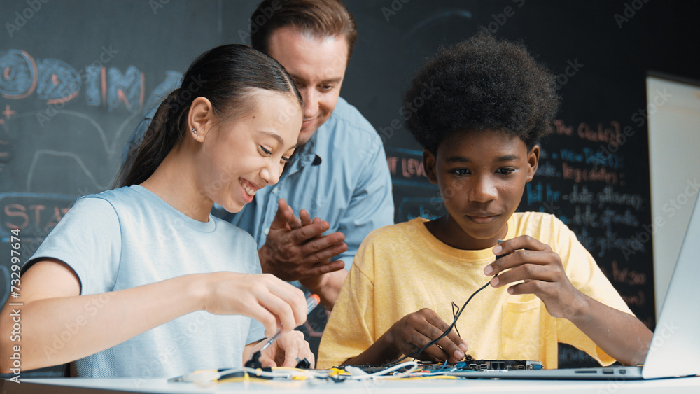 Caucasian teacher talking about electric tool while student fixing ...