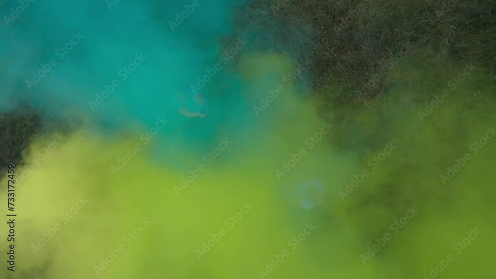 An overhead shot captures a couple in a grassy field, joyfully holding ...