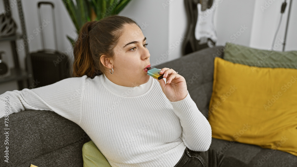 Young hispanic woman relaxing on sofa in modern living room while ...