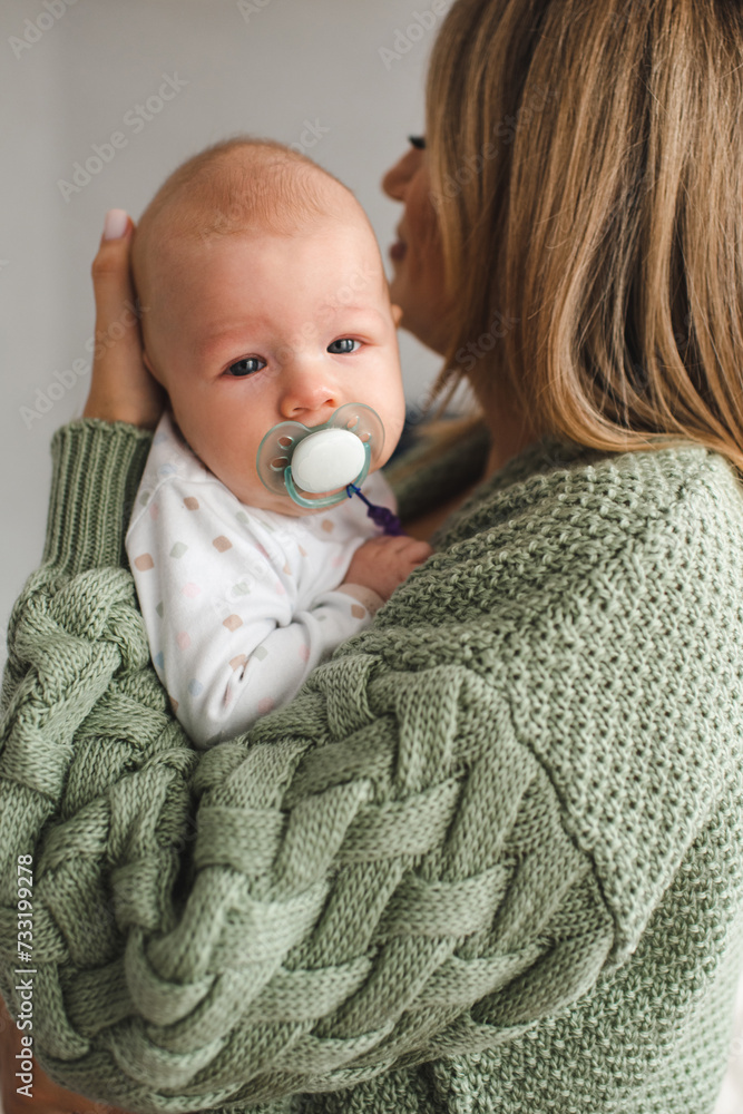 Sad crying baby with tears on his eyes on mother hands close up ...