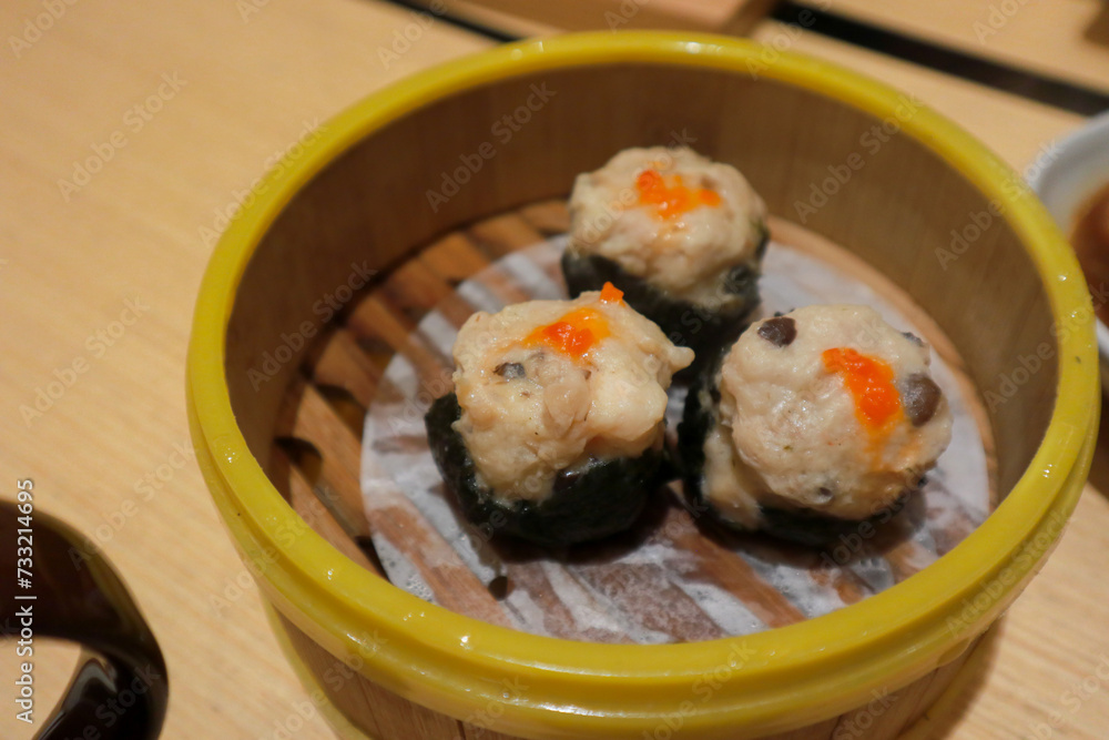 Chicken dimsum served in bamboo plate. Dimsum is a large range of small dishes that Cantonese ...