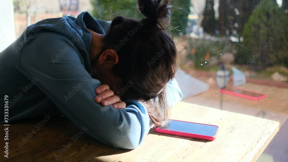 An exhausted young businesswoman indoors, grappling with overwork ...